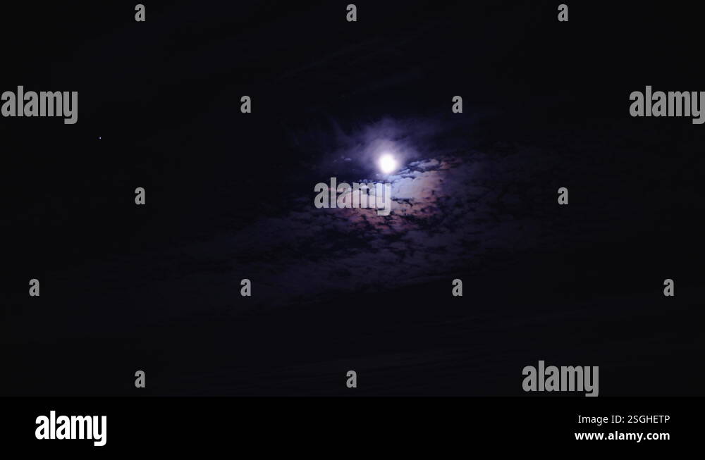 Fast movement, the full moon shines through the clouds flying through ...