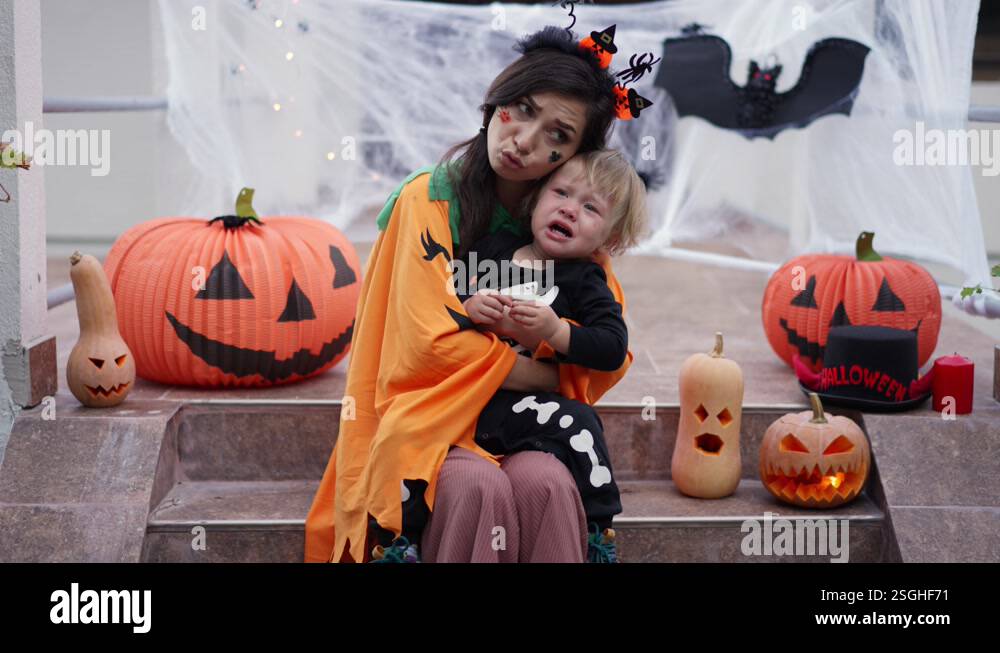 a child dressed as a skeleton for Halloween is crying from fright and a ...