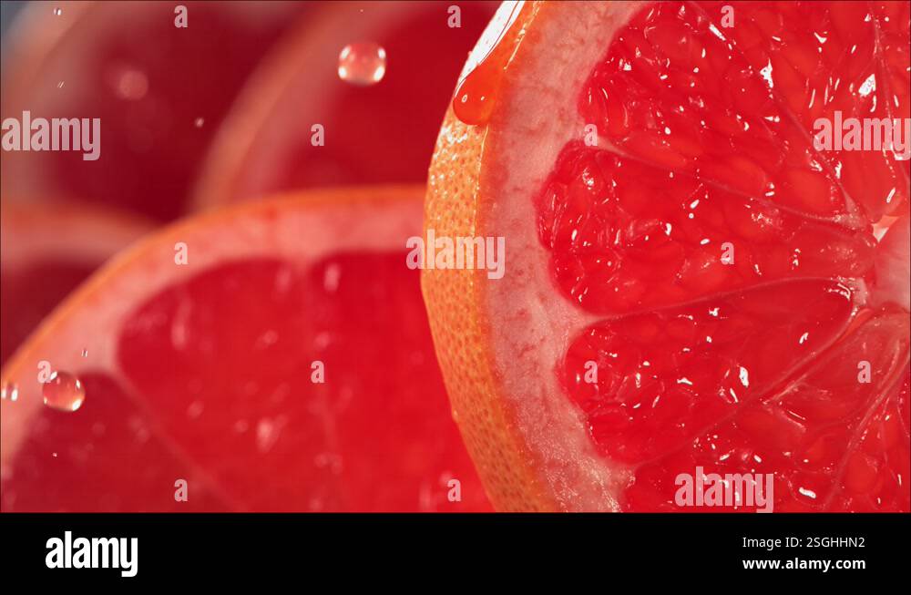 Drop of Grapefruit Juice flows down the surface of a ripe juicy ...
