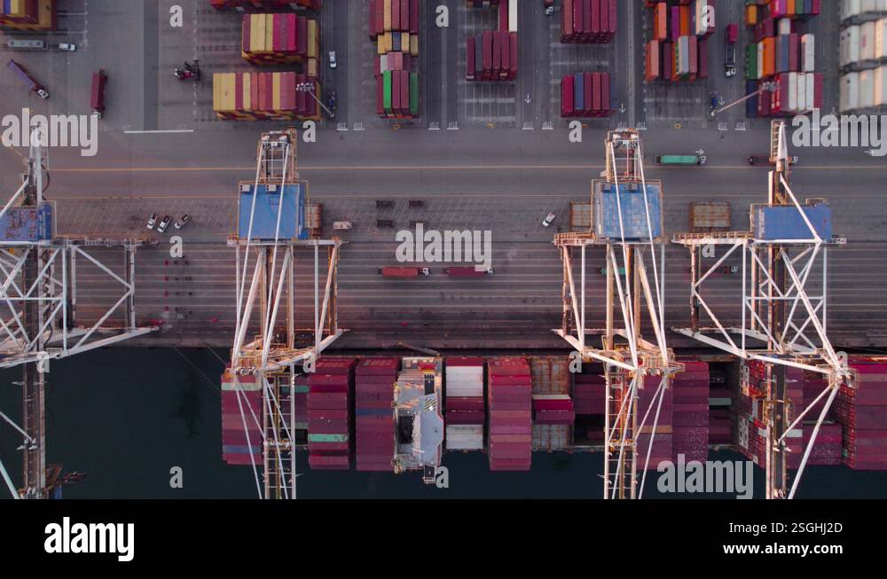 Cargo terminal loading shipping containers onto cargo ships, aerial ...