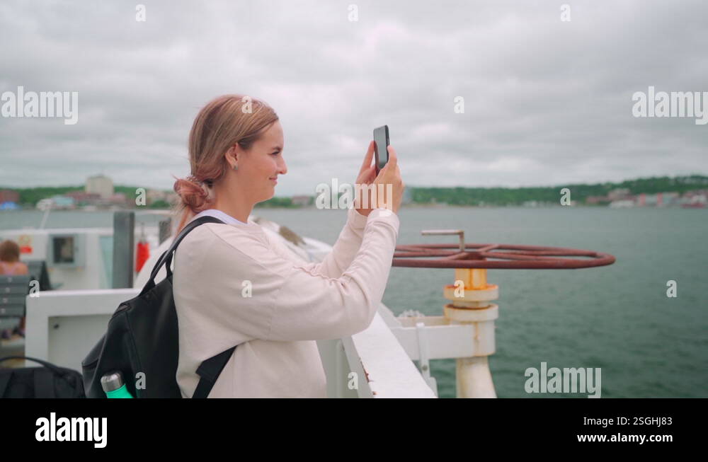 Woman with pink hair on the coast of eastern Canada taking a phone on ...