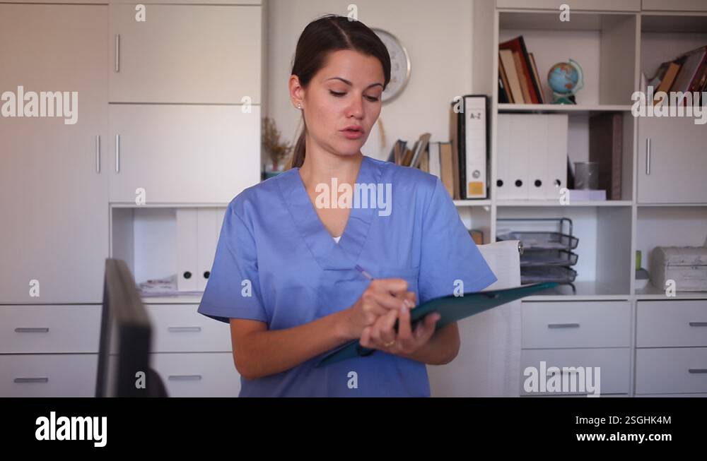 Positive nurse with folder of documents at clinic office Stock Video ...