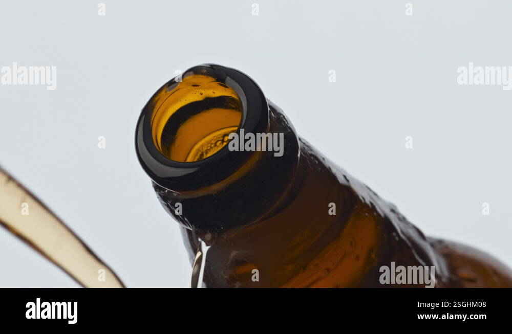 Uncorking glass beer bottle closeup. Foamy carbonated cider pouring ...
