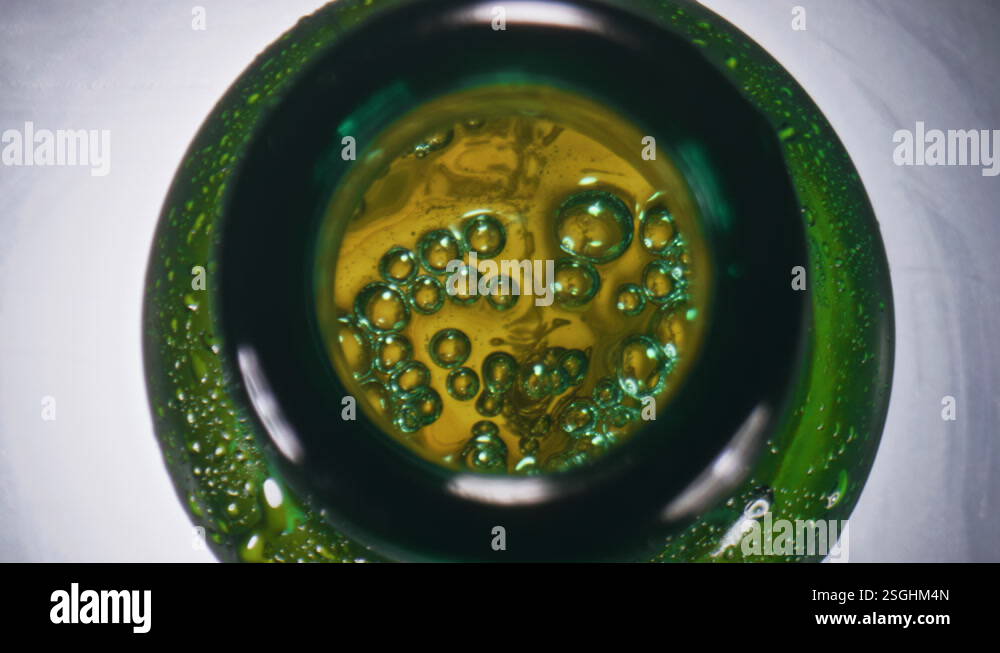 Closeup effervescing beer vessel. Alcoholic liquor bubbling inside ...