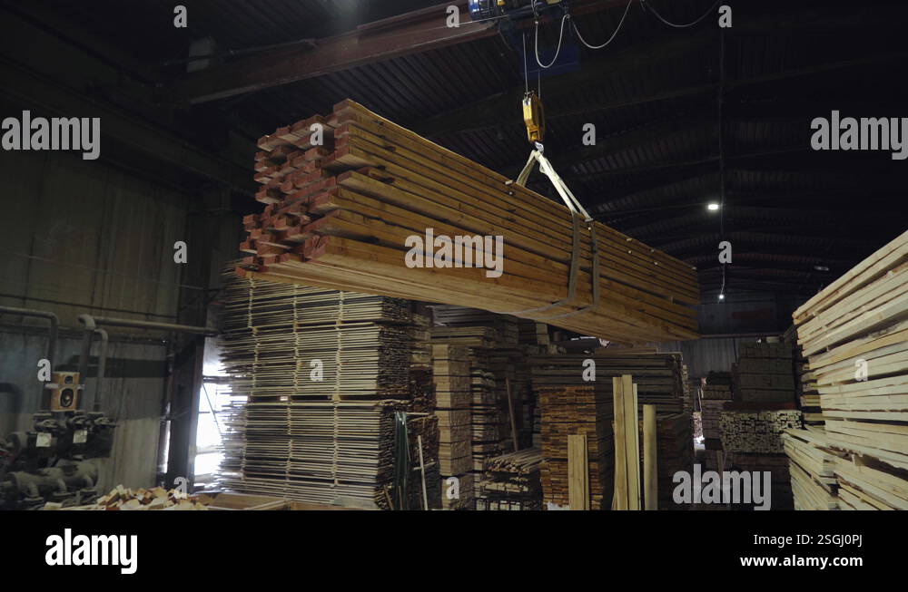 Industrial Crane Moving Bunch Of Wood Boards In Lumber Warehouse At ...