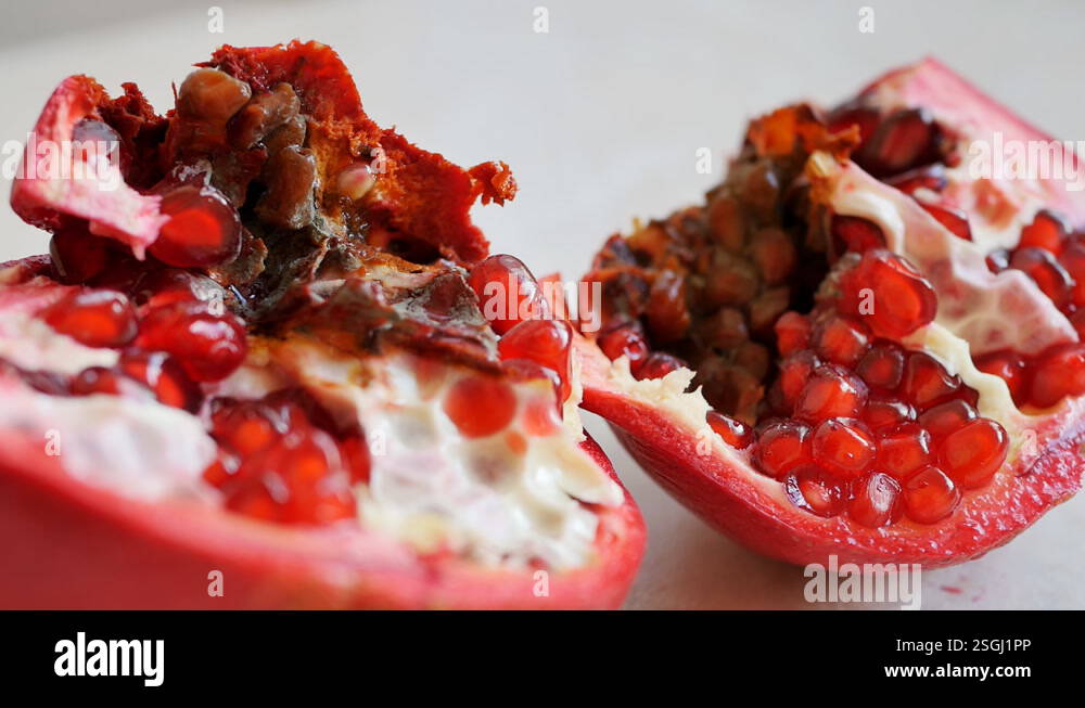 Close-up of a spoiled pomegranate rotted inside broken into two halves ...