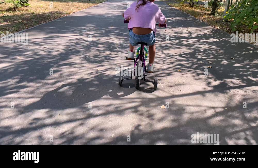 A girl cyclist in the park is active outdoors. A bicycle ride in the ...