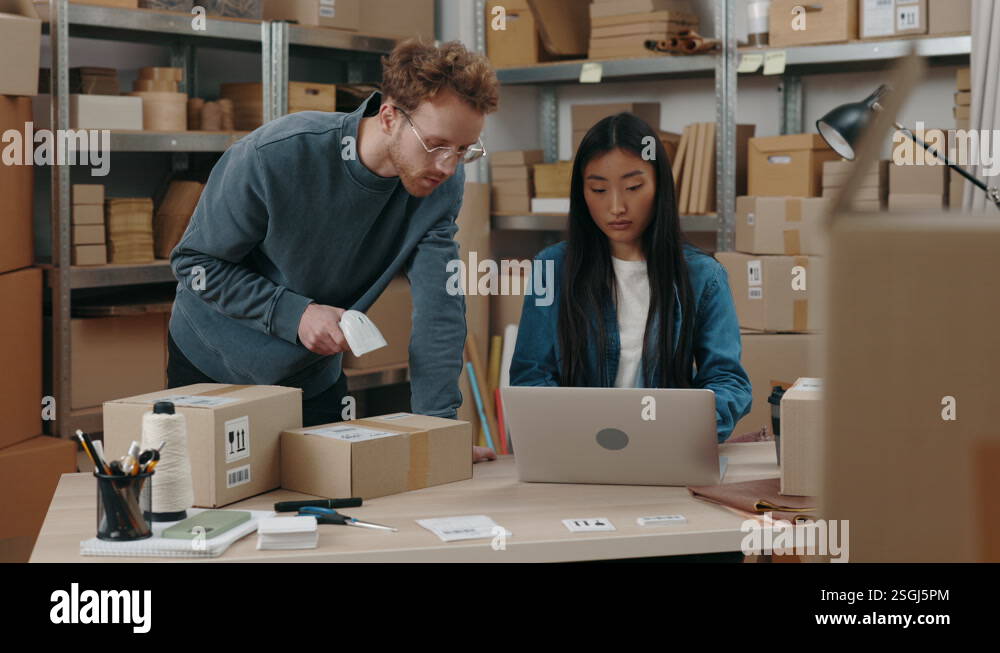 Inventory managers scans cardboard box with barcode scanner in the ...