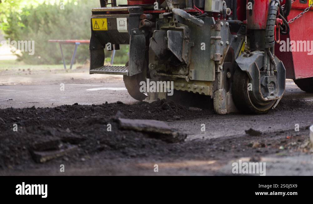 shot from a industrial machine destroying the tar on the road and ...