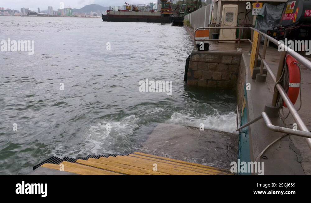 Sea currents splash water at the harbor waterfront deck after a severe ...