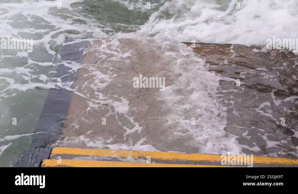 Strong sea currents splash water at the harbor waterfront as a severe ...