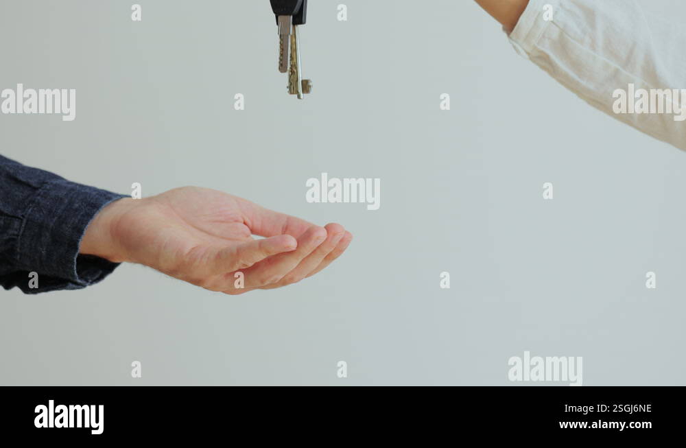 Close up of male hand passing key to female in new apartament. Man ...