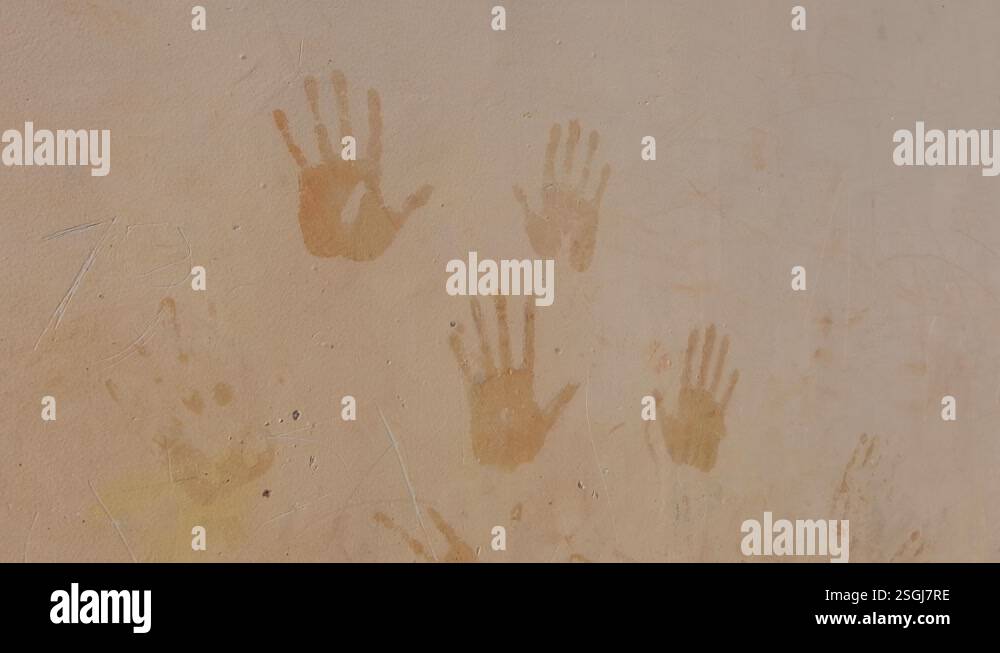 Multiple arty handprints painted onto a rustic light coloured wall of ...