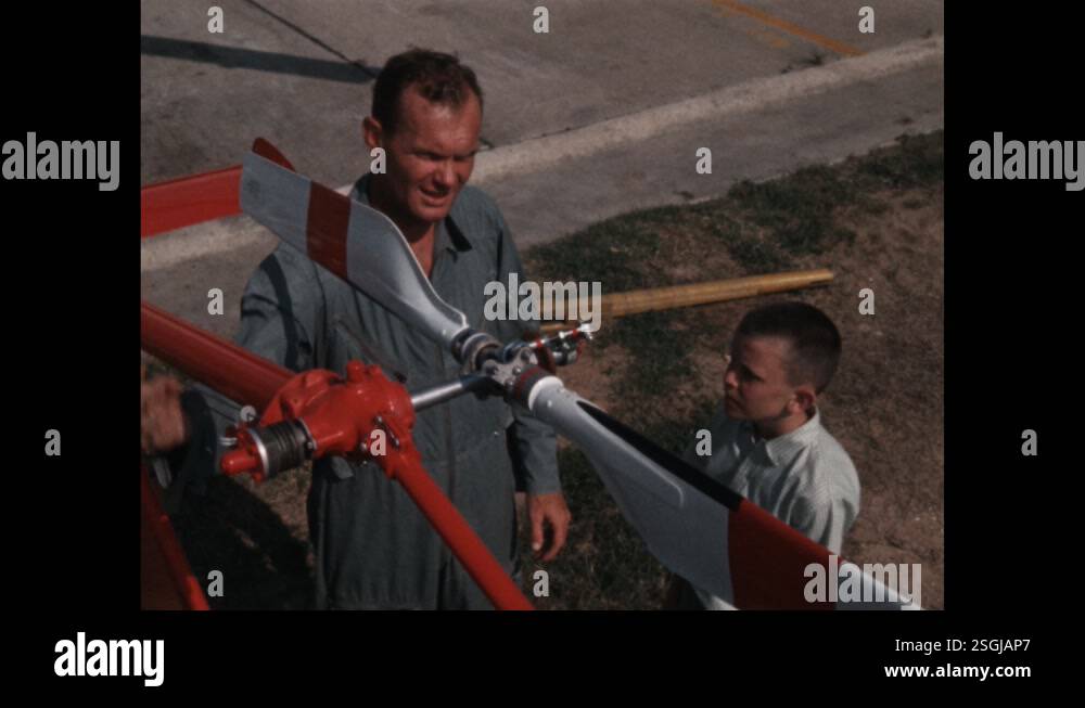 1960s: Pilot showing boy how tail rotor functions. Pilot showing boy ...