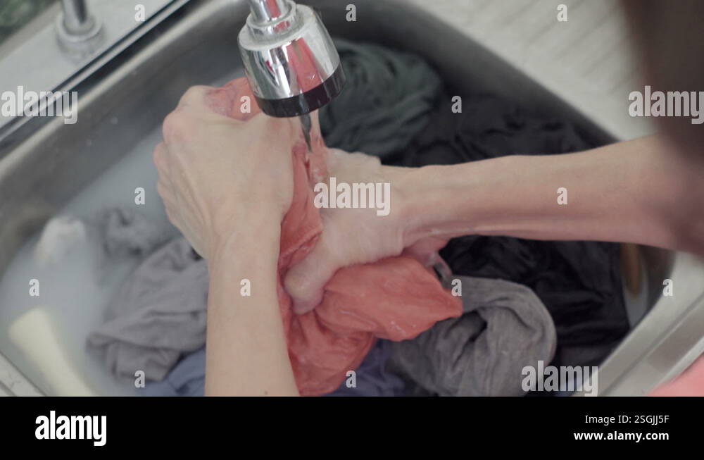 Over the Shoulder Handheld Washing Cothes in Sink Stock Video Footage ...