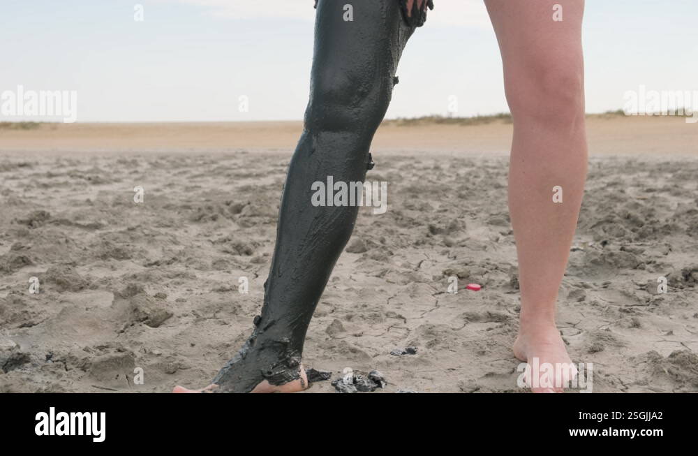 Mud therapy, woman applying healing mud to her body on firth Stock ...