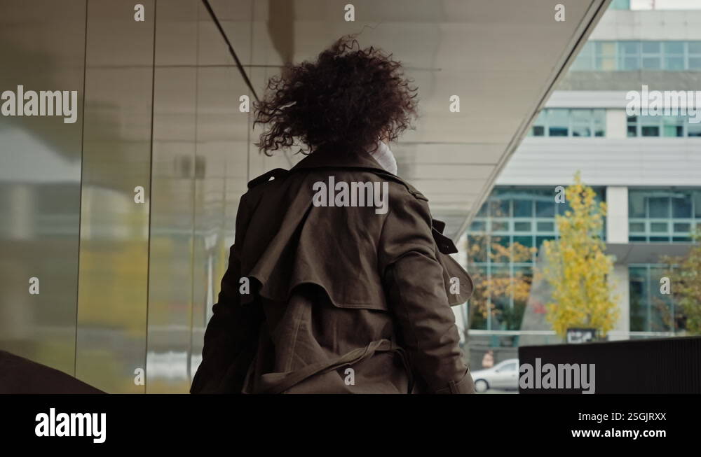 Following urban style female runs turning around smiling laughing in ...