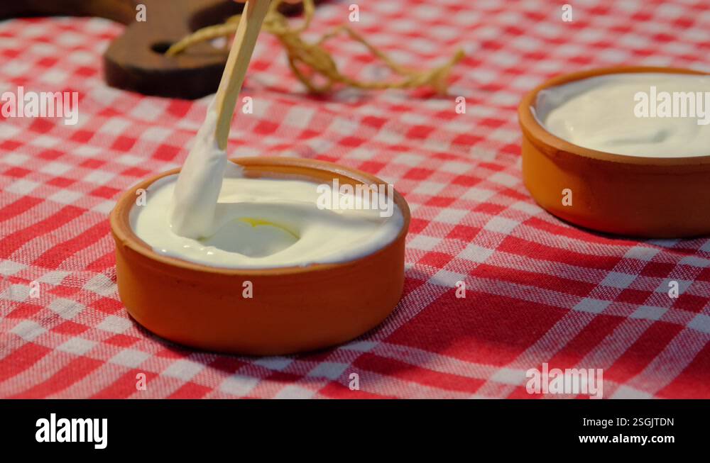 With spoon fresh yogurt close up.Mixing yogurt in bowl.4K UHD video ...