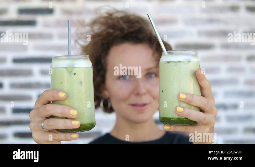 Slow motion with focus on glasses with milkshakes. They are held in the ...