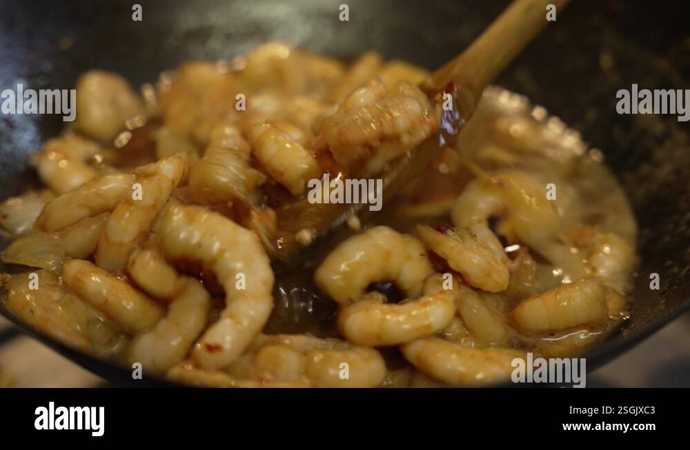 Prawns Being Stirred In Sauce Inside Wok With Wooden Spoon. Slow Motion ...