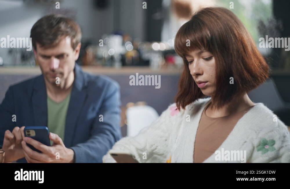 A man and a woman on a date in a cafe are sitting on the phones Stock ...
