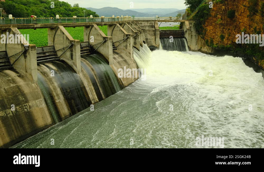 hydroelectric power-plant dam on a river with water overflowing the dam ...