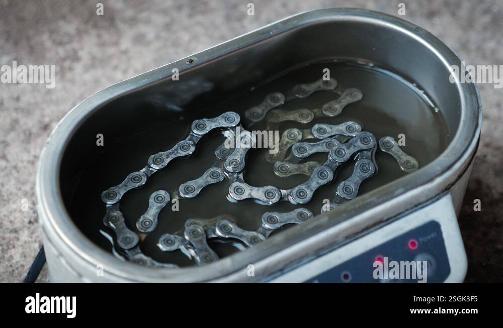 Bike mechanic opening ultrasonic bath with bicycle chain inside Stock ...