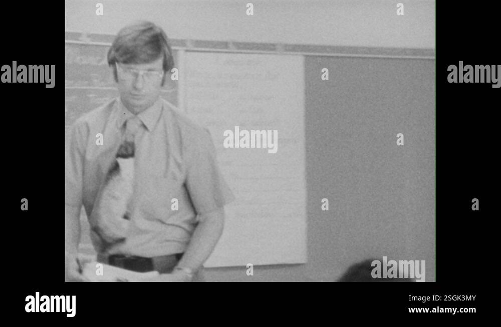 1970s: Students line up and get ready to go to recess. Chalkboard: We ...