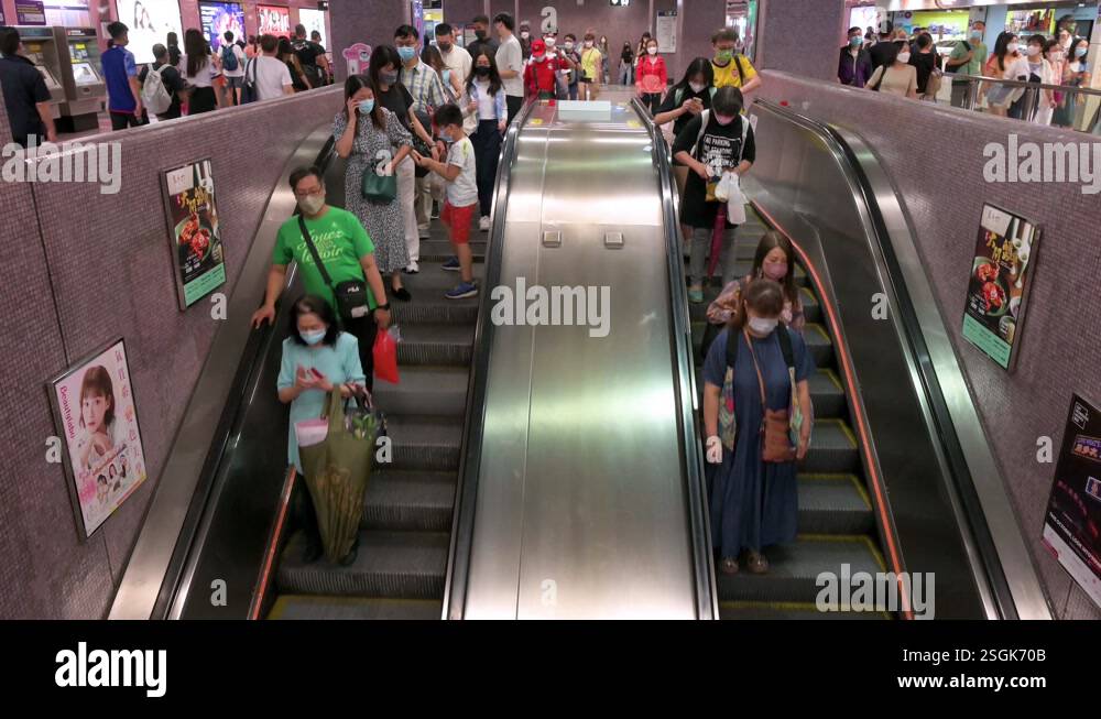 Chinese commuters ride on automatic moving escalators at a crowded ...