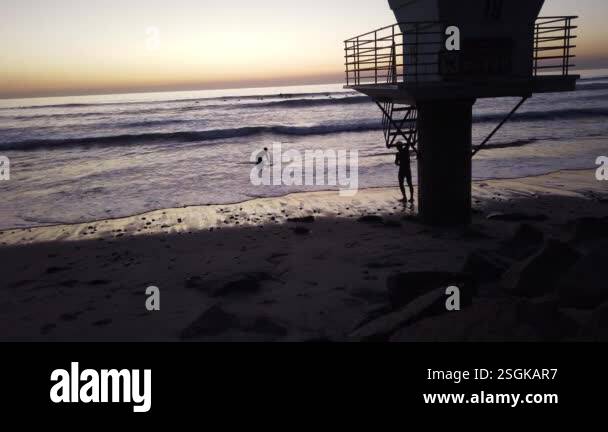Surfers at Tower 19 Cardiff. Low tide on a Southern California beach at ...