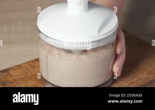 chef blending canned beans with garlic and lemon juice in blender in ...
