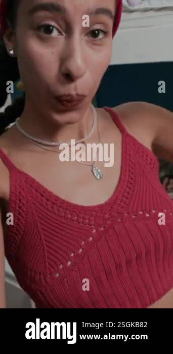 Vertical UGC shot of joyful female student wearing knitted top and ...