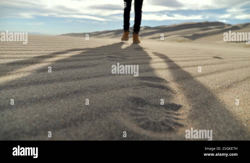 Explorer Walking Away from Camera Leaving Footprints in the Sand in the ...