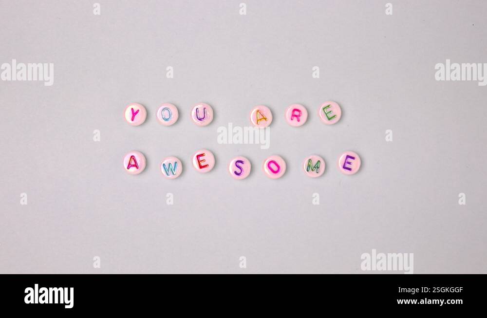 You are awesome. Quote made of white round beads with colorful letters ...