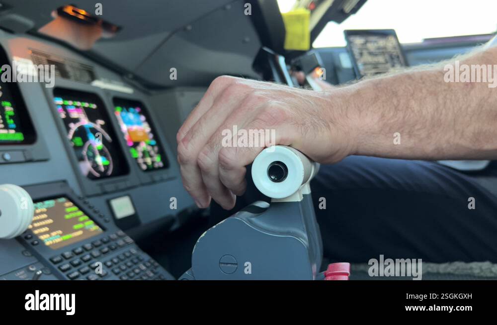 Close view inside a jet cockpit while copilot is handling thrust levers ...