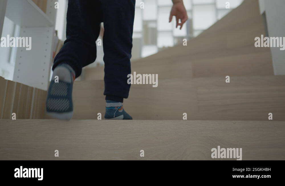 Child feet walking up the stairs. Kid legs climbing staircases at home ...