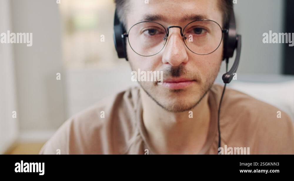 Camera zooming in on face of young Caucasian male worker of client ...