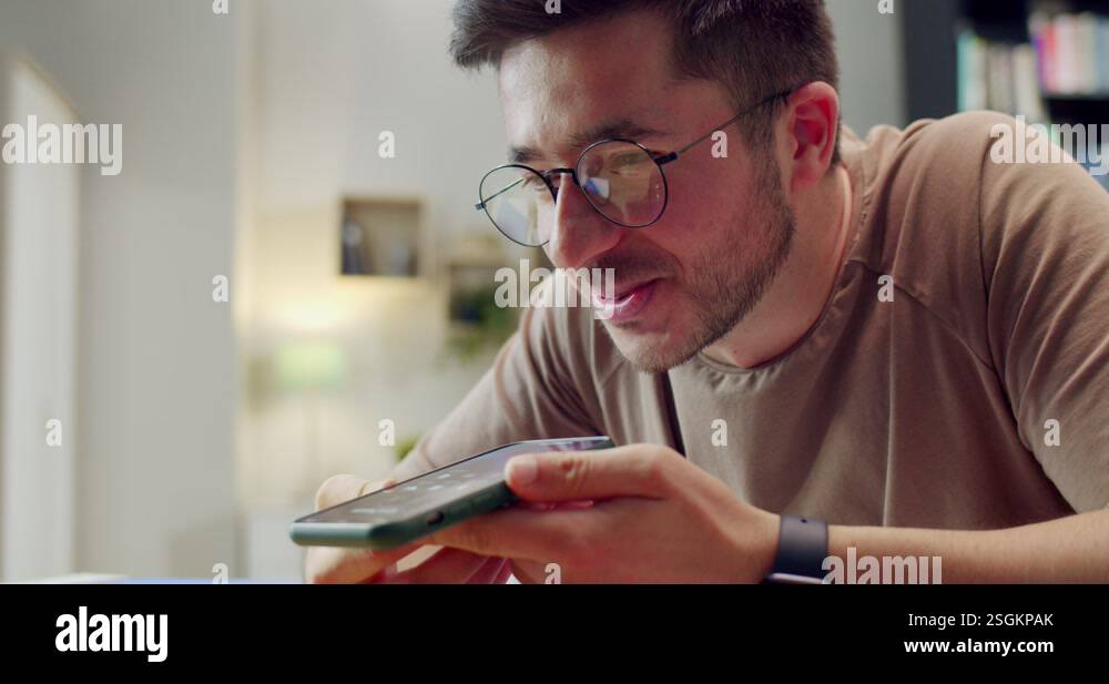 Cheerful happy smiling Caucasian man in glasses recording voice message ...