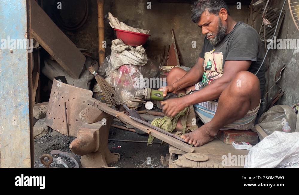 Close up shot of man sharpening and shaping a sword blade by wielding ...