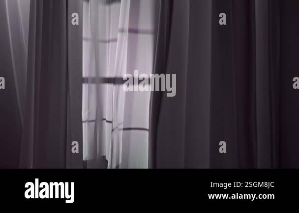 Windows with colorful tulle fabrics blown by the wind. Transparent silk curtains in monochrome ...