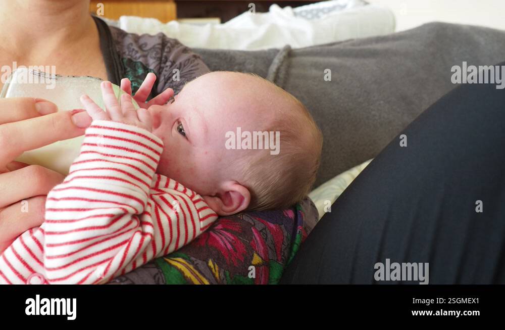 Mother feeding baby with bottle of milk. Side view medium Stock Video ...