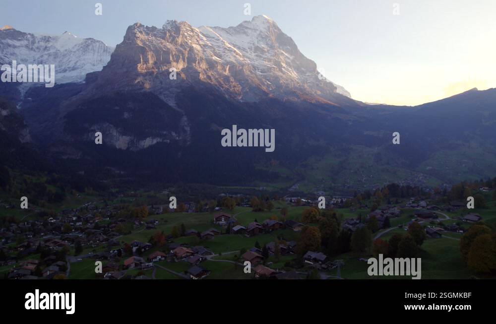 aerial drone footage pushing out over Grindelwald village, sunset view ...
