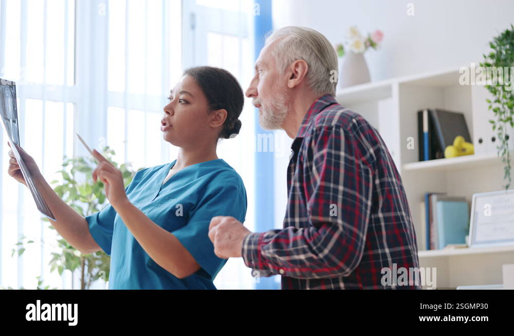 Female traumatologist explaining x-ray test result to her patient, bone ...
