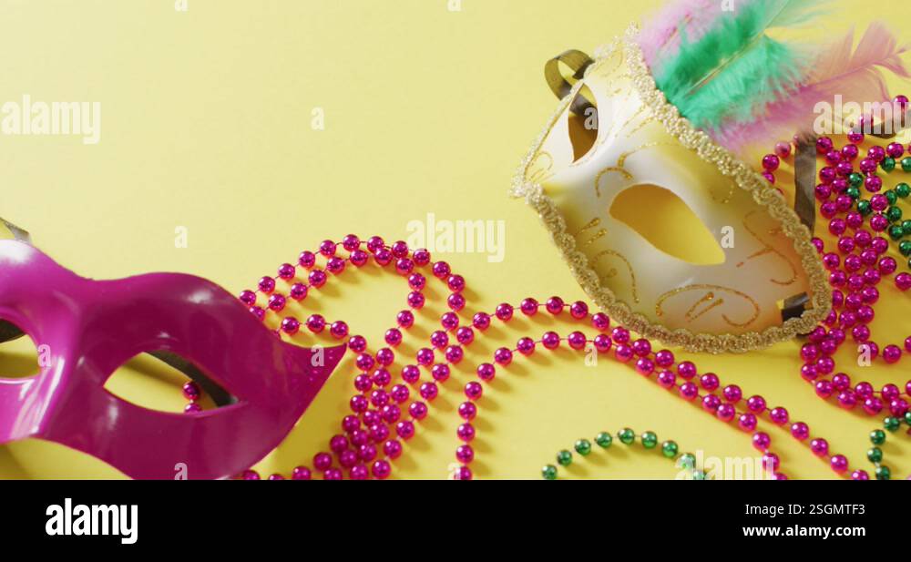 Video of two masquerade masks and carnival mardi gras beads on yellow ...