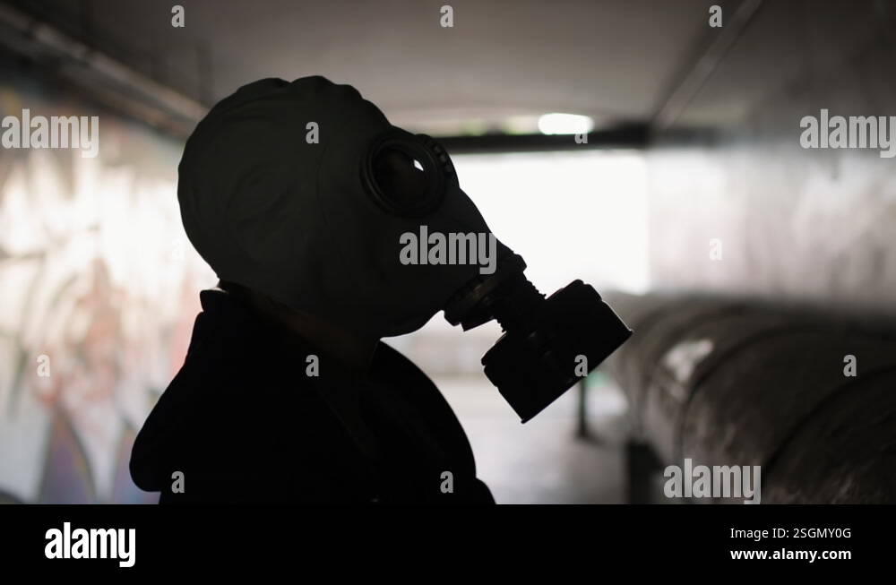 Silhouette of a person in a gas mask in a radioactive zone. Concept of ...