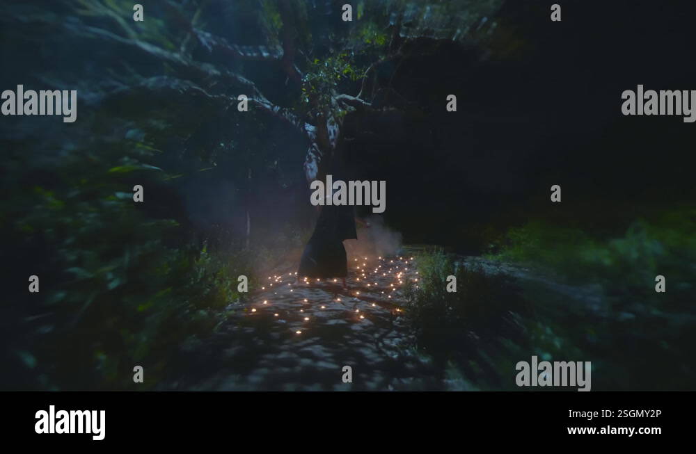 Mystic shaman in black robes dancing under tree in dark forest ...