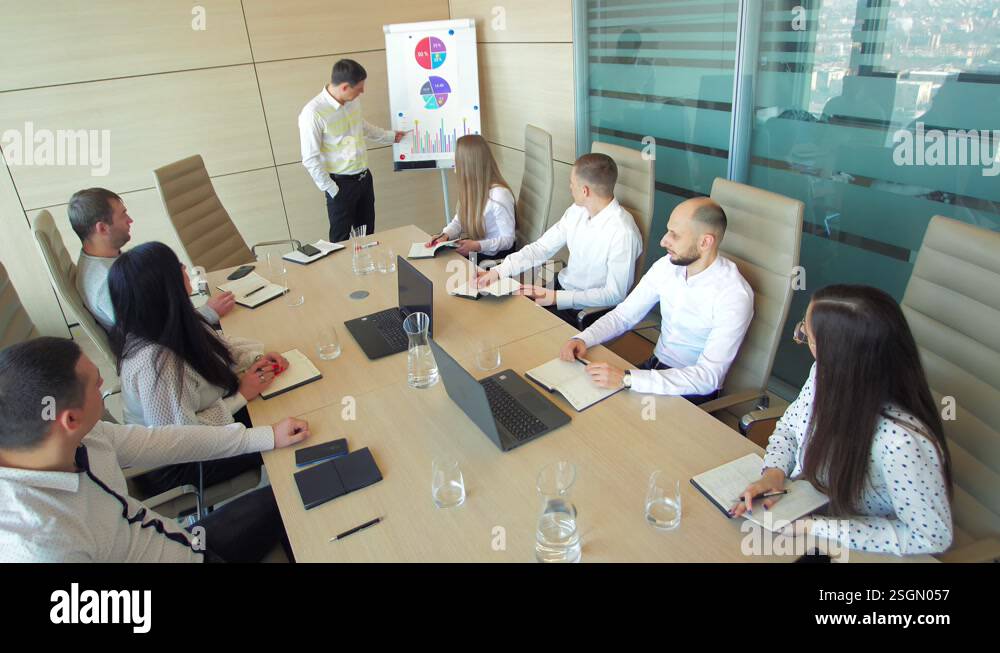 Top view of young male manager presenting project plan to colleagues in ...