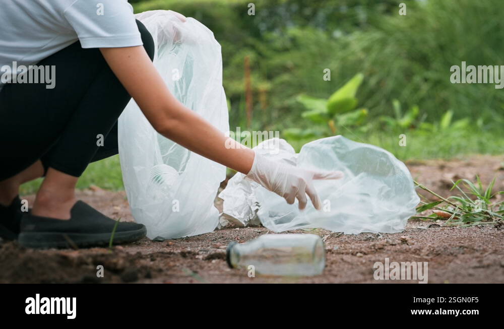 woman is collecting recycling junk on ground , ecological sustainable ...