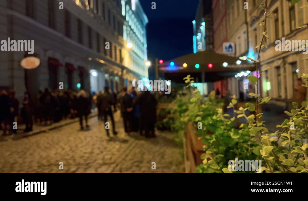 Group of people partying outdoors in the city centre near a bar ...