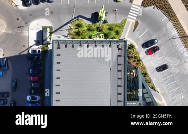 Aerial view of a parking lot with multiple cars parked around a modern ...